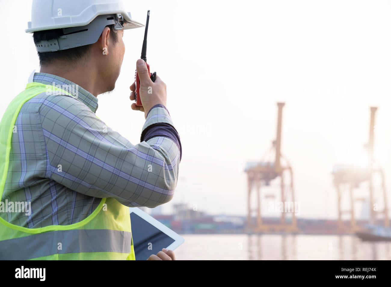Asian man engineer radio and tablet and working with container Cargo ...