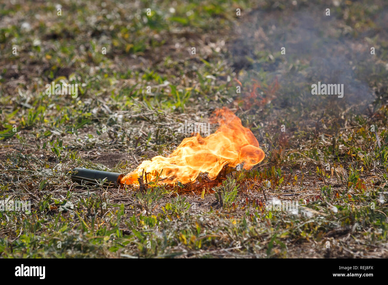 Burning smoke grenade lies on the battlefield Stock Photo - Alamy