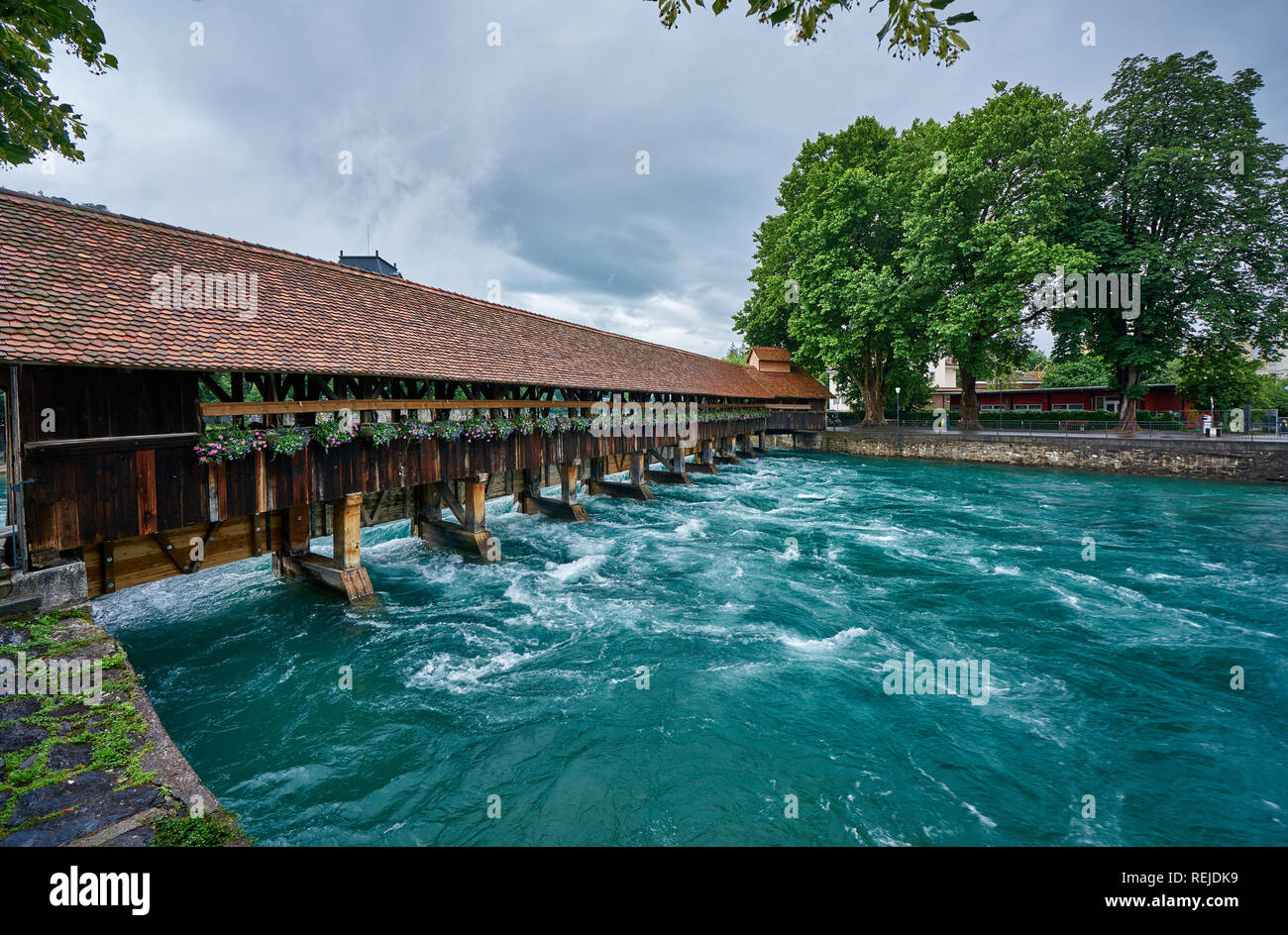 Panorama of Thun with old wooden bridge over Aare river. Thun town is ...