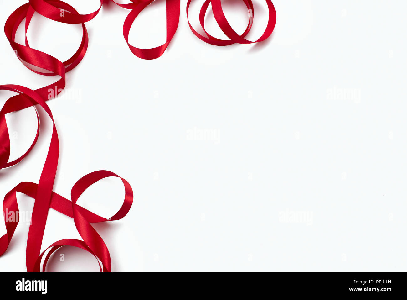 Decorative frame of red satin ribbon white background. Top view copy ...