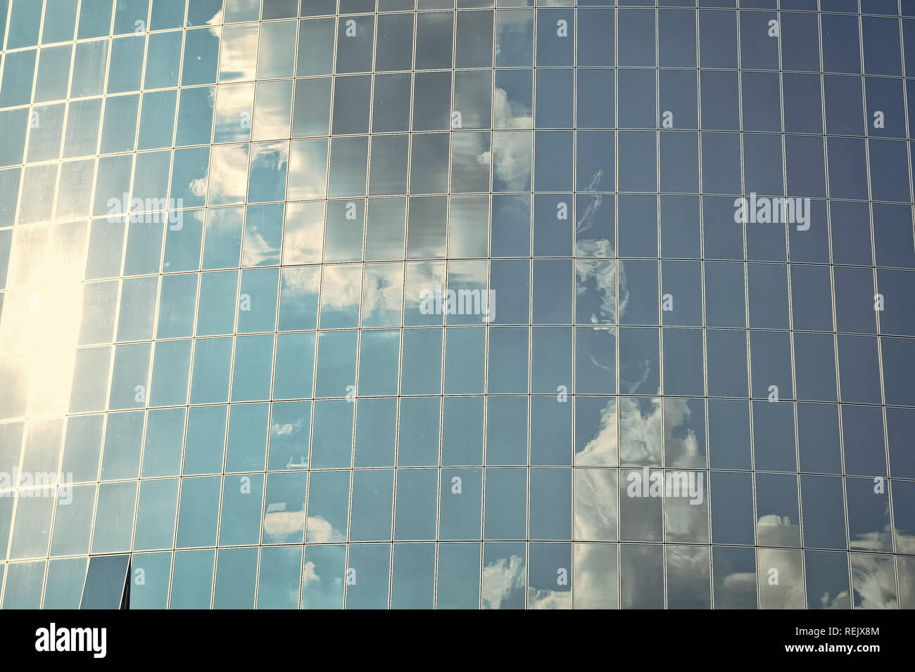 Clouds reflected on glass facade wall of building. Cloudy blue sky ...