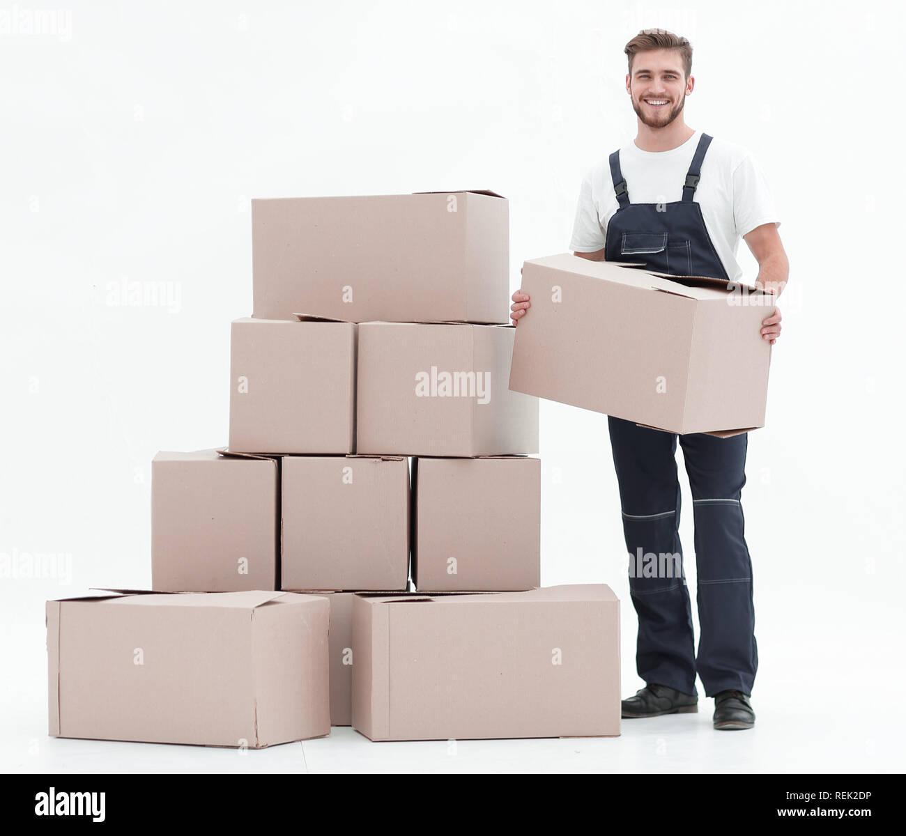 Young man carrying a box to the pile of boxes Stock Photo - Alamy