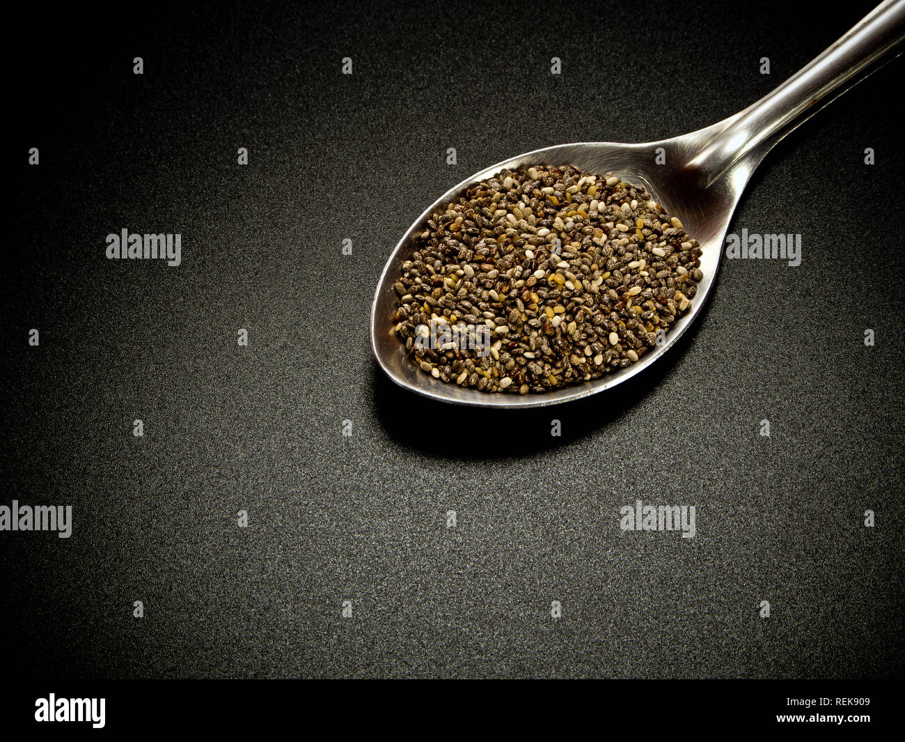 Chia seed in light on dark background Stock Photo - Alamy