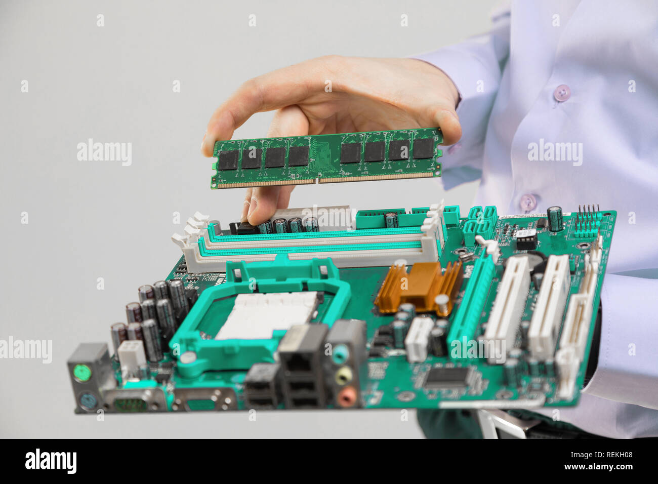 RAM and motherboard in men's hands close-up isolated on light ...