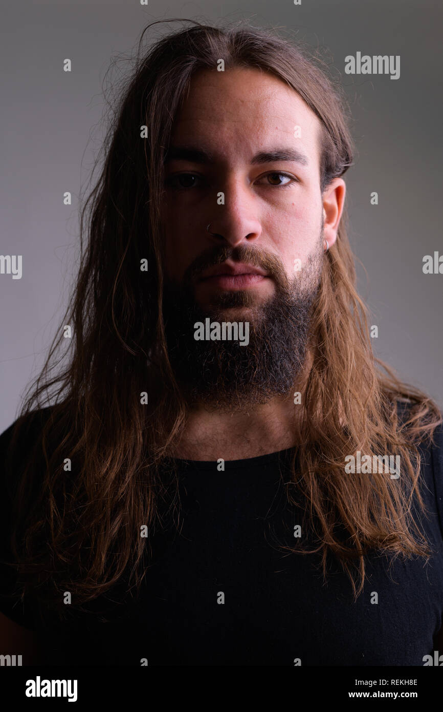 Face of young handsome bearded man with long hair Stock Photo - Alamy