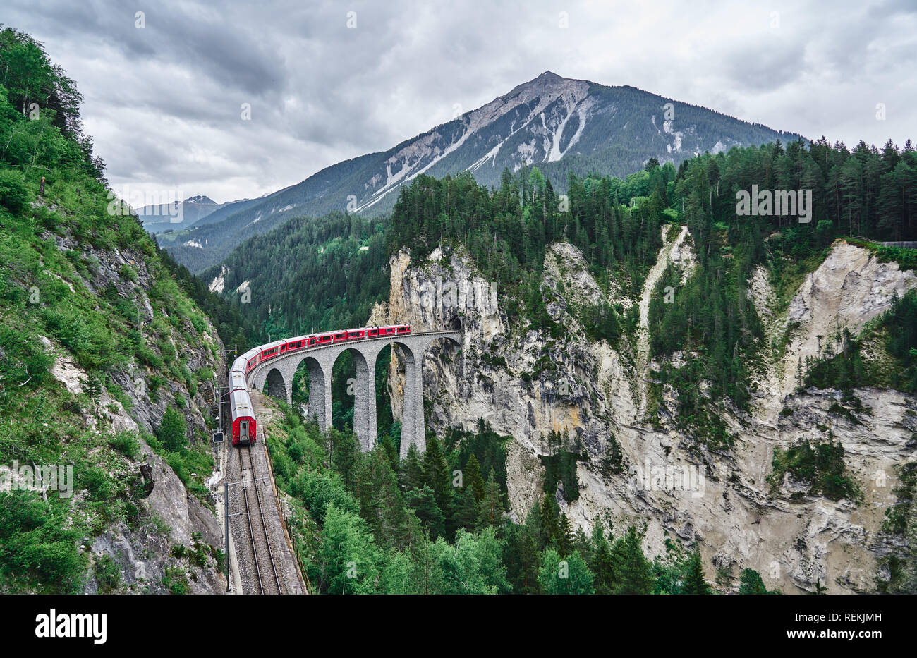 Red train passes above the Landwasser Viaduct bridge, in canton of ...