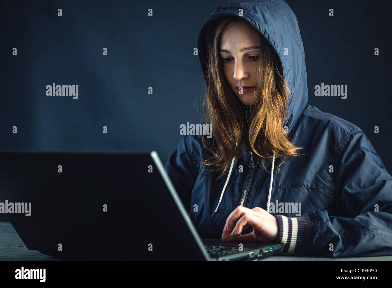 Girl hacker uses a laptop to hack the system. Stealing personal data ...