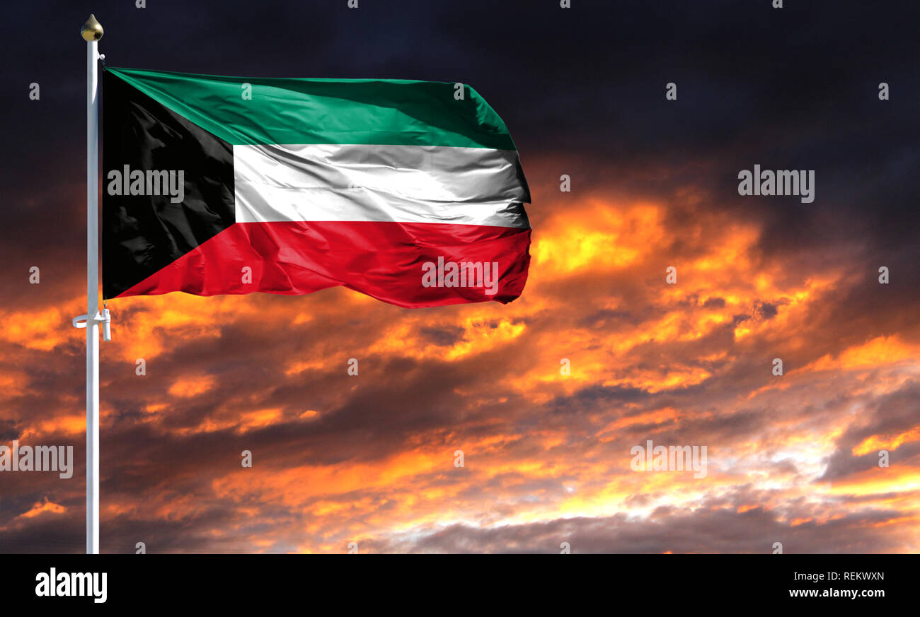 flag of Kuwait on flagpole fluttering in the wind against a colorful ...