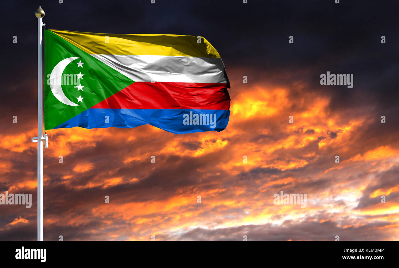 flag of Comoros on flagpole fluttering in the wind against a colorful ...