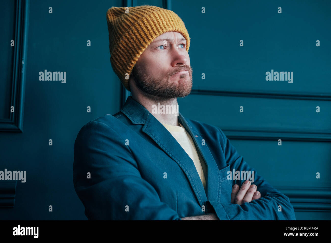 Attractive adult bearded angry man hipster in yellow hat looks at ...