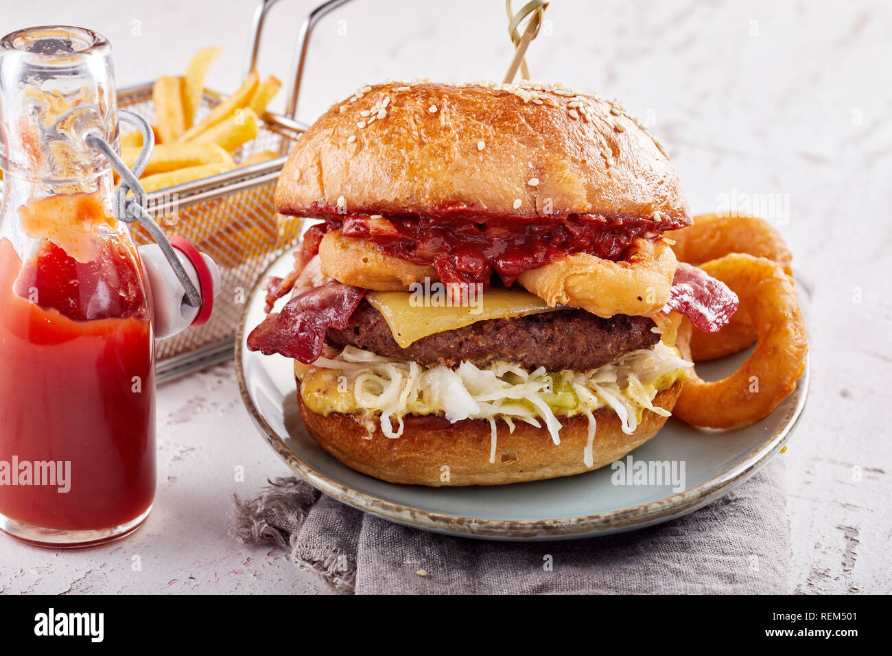 Surf and turf burger with squid rings, crispy bacon and a meat patty ...