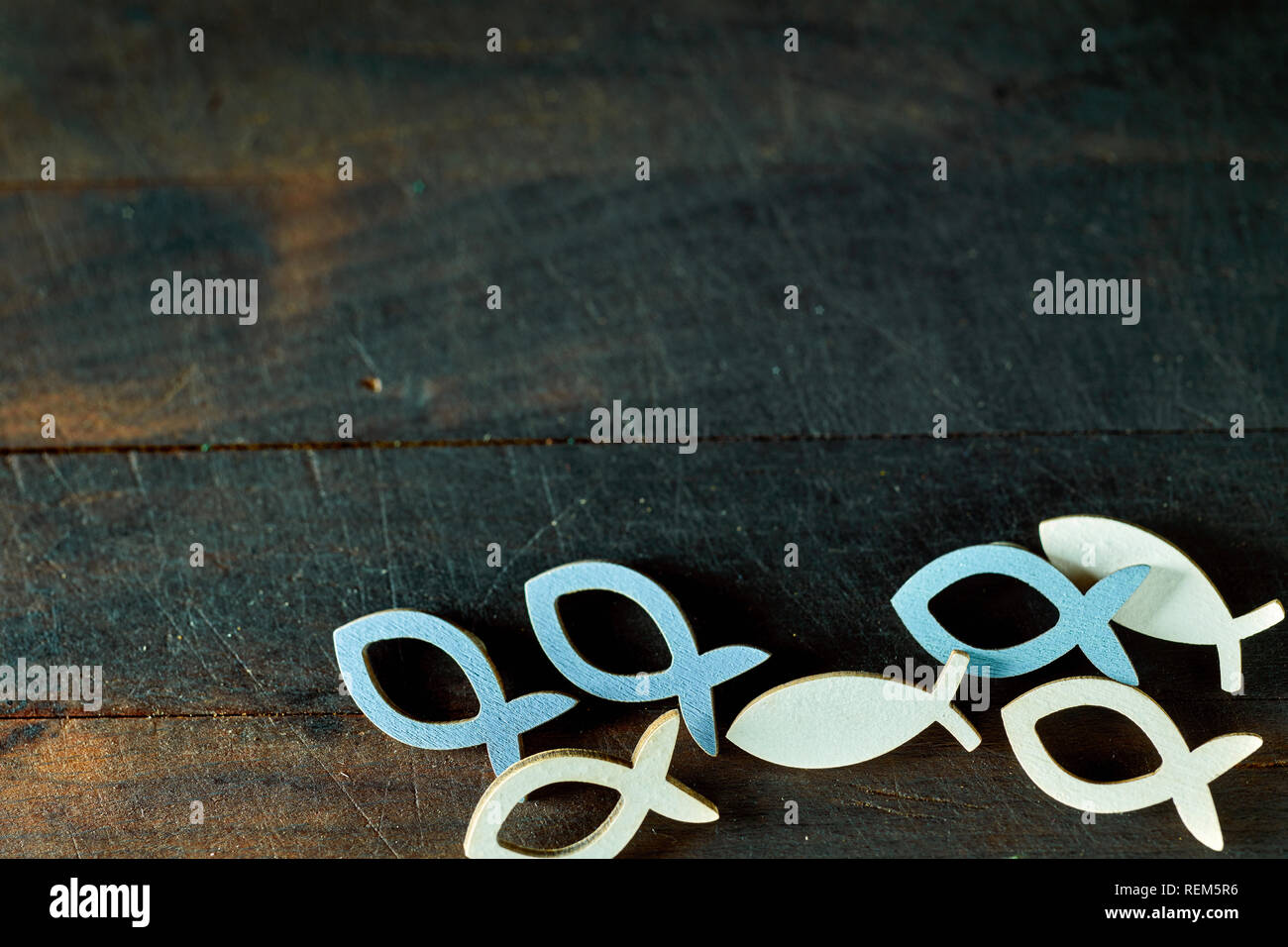 Blue and white handmade fish shapes on dark wooden surface as simple ...