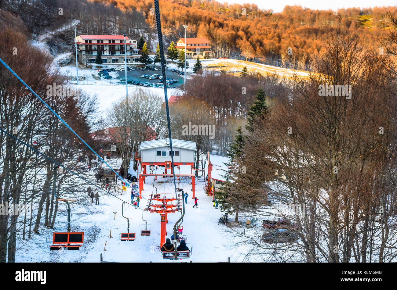 People on the lift enjoy the stunning view of the famous greek ski ...