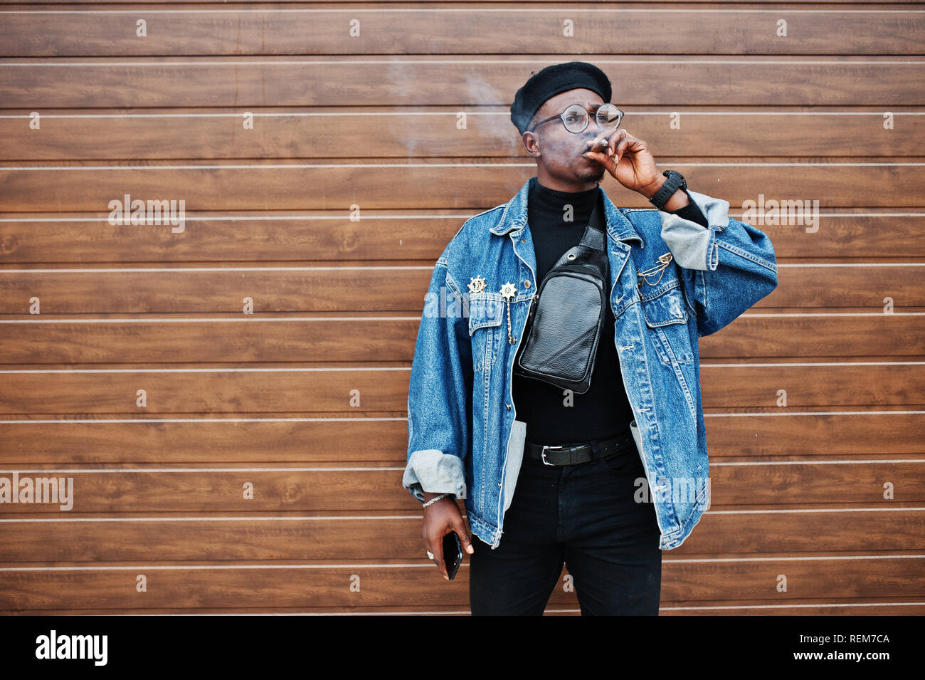 African american man in jeans jacket, beret and eyeglasses, smoking ...