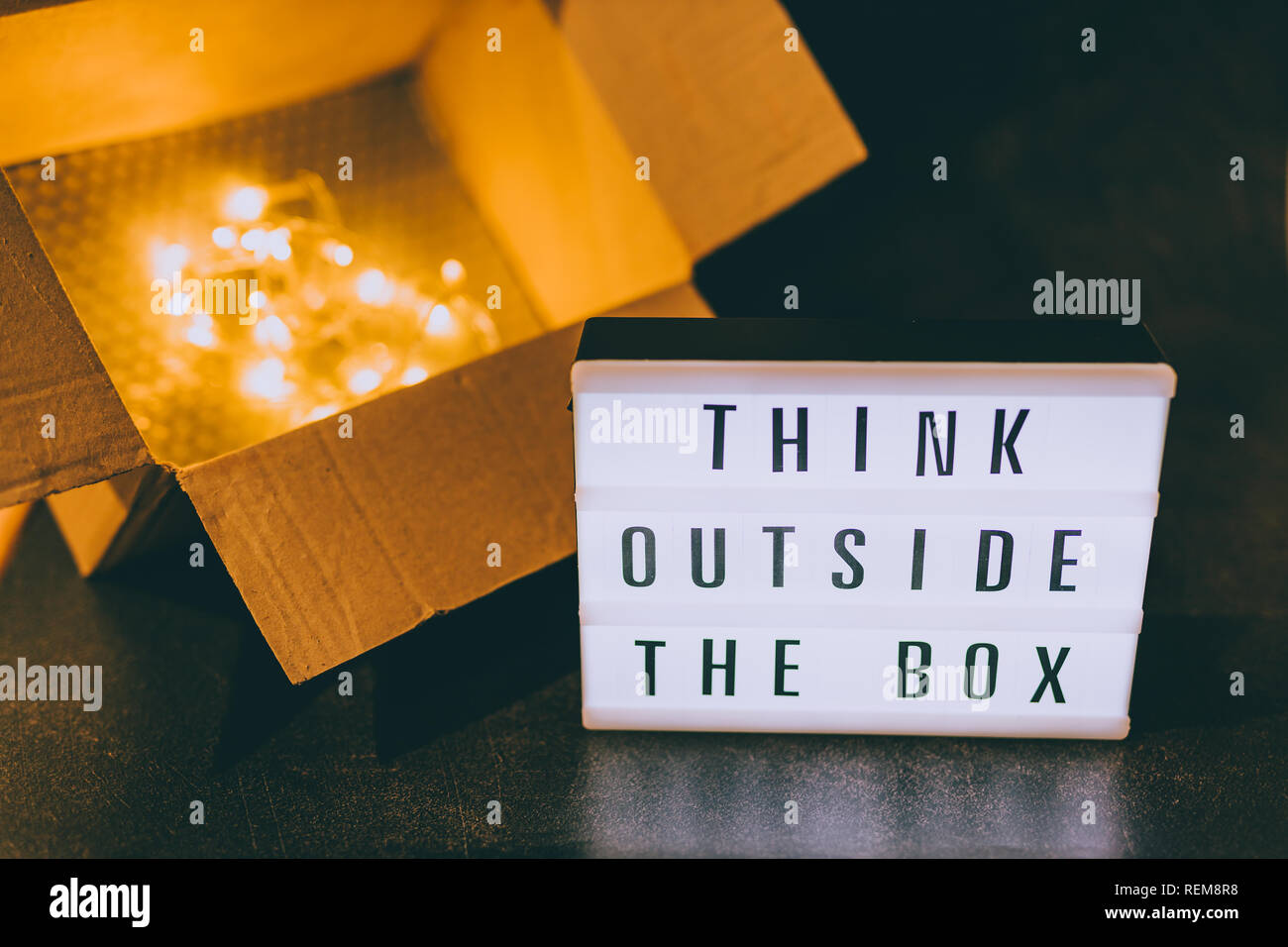 Think outside the box message on lightbox next to open parcel with ...