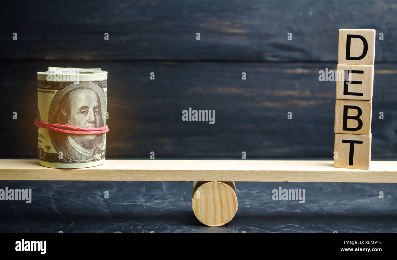 Dollars and the inscription "Debt" are on the scales. Concept of ...