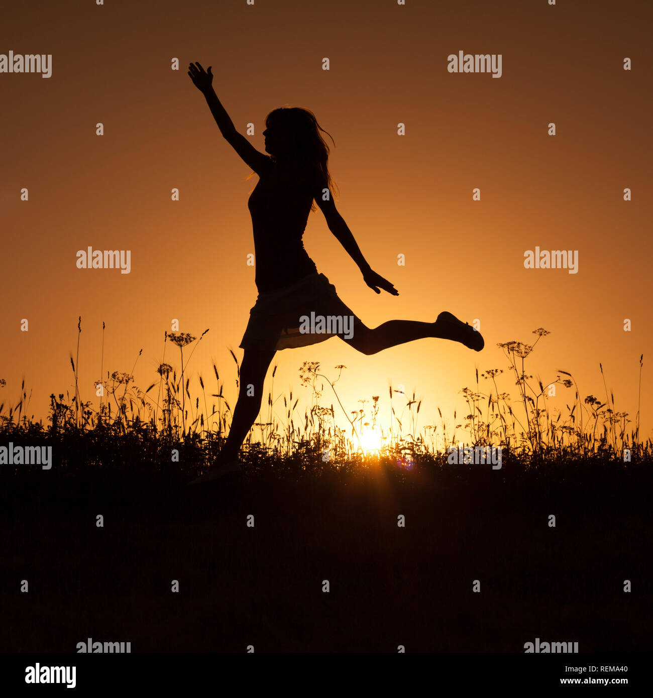 Silhouette of happy woman jumping in sunset Stock Photo - Alamy