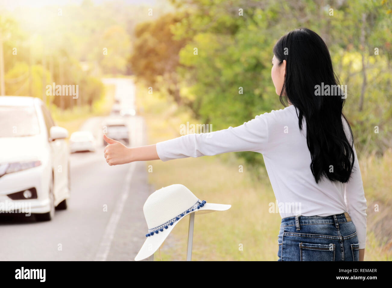 Hitchhiking tourism concept. Travel hitchhiker woman walking on road ...