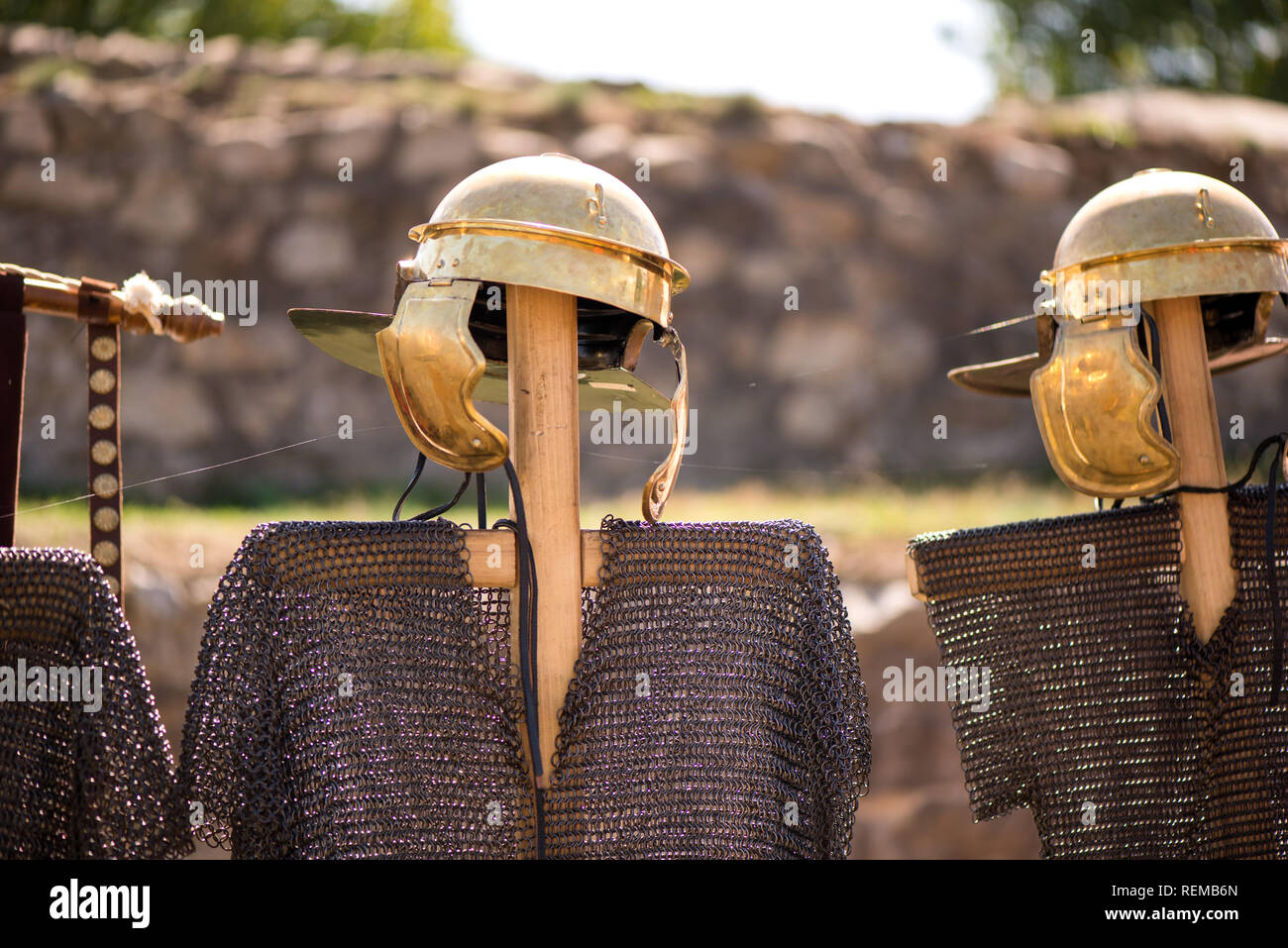 Medieval knight's iron chain armor and golden helmets on wooden cross ...