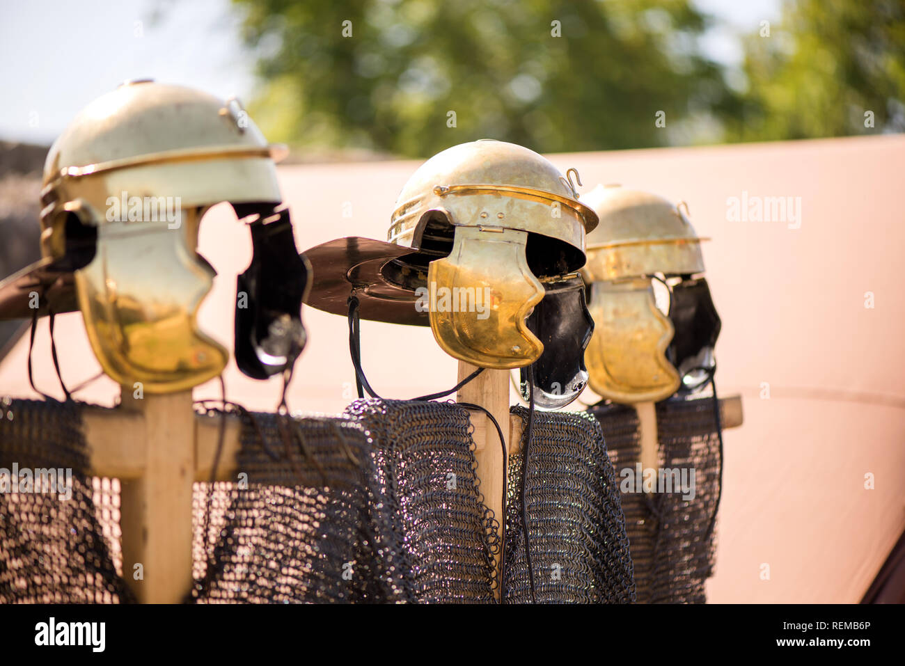 Medieval knight's iron chain armor and golden helmets on wooden cross ...