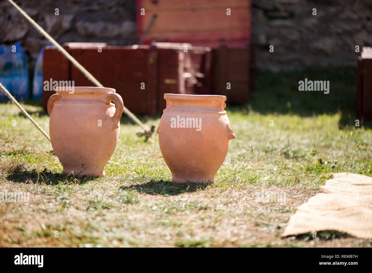 Clay pots standing in middle of medieval garden. Settlement on a ...