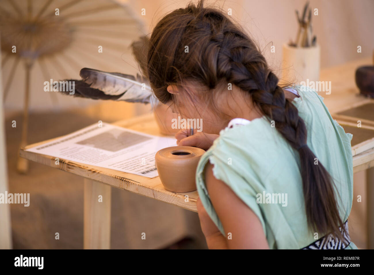 Young girl is writing with old quill pen on the old paper. Historical ...