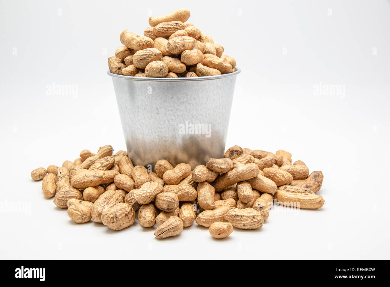 Peanuts in a tin bucket on white background Stock Photo - Alamy