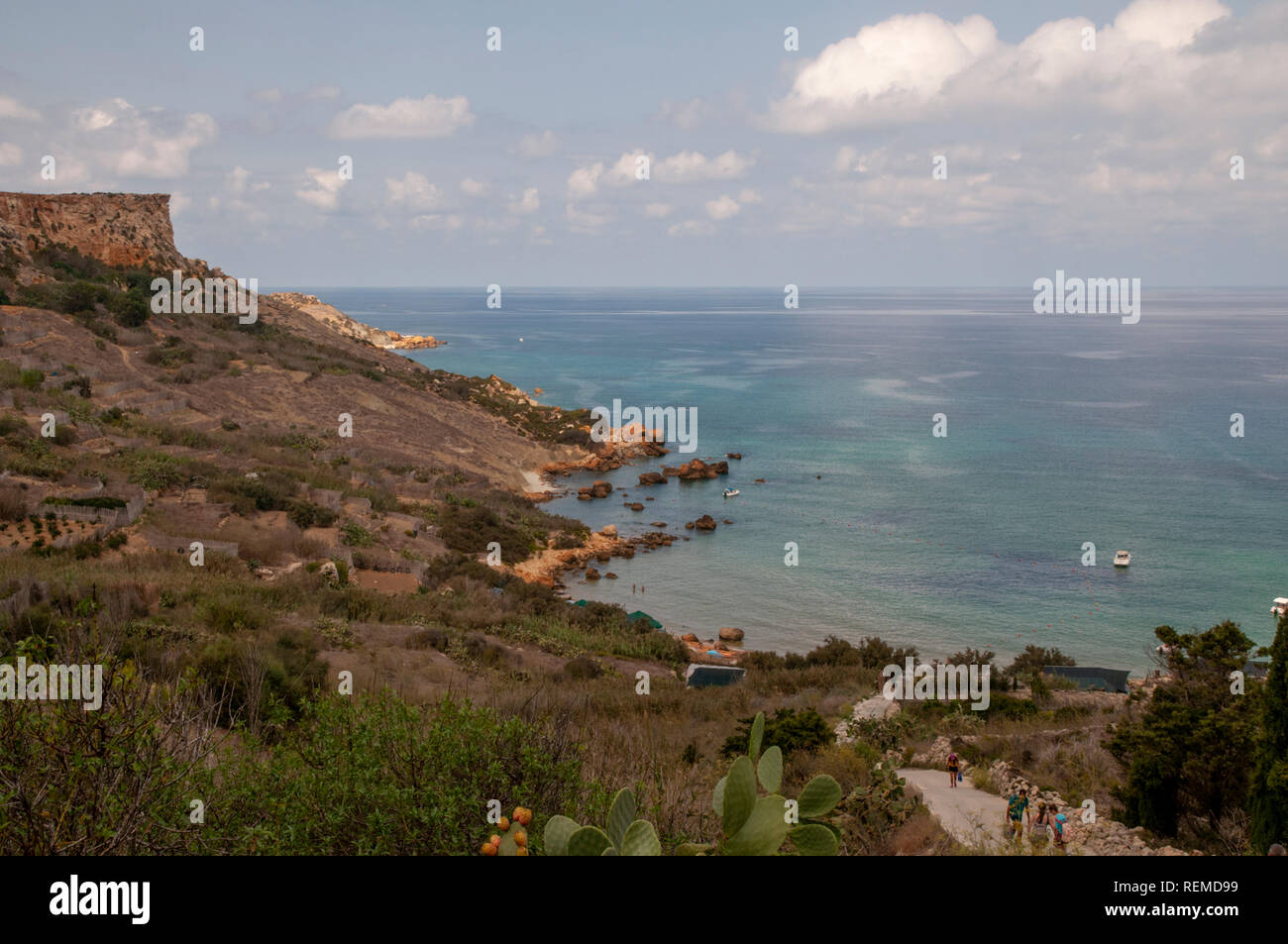 Looking over quiet San Blas Bay and its beach with red sand on Gozo ...