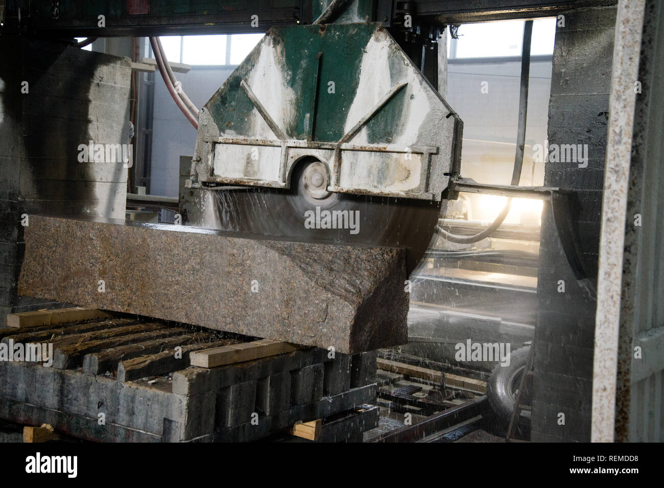 Granite processing in manufacturing. Cutting granite slab with a ...