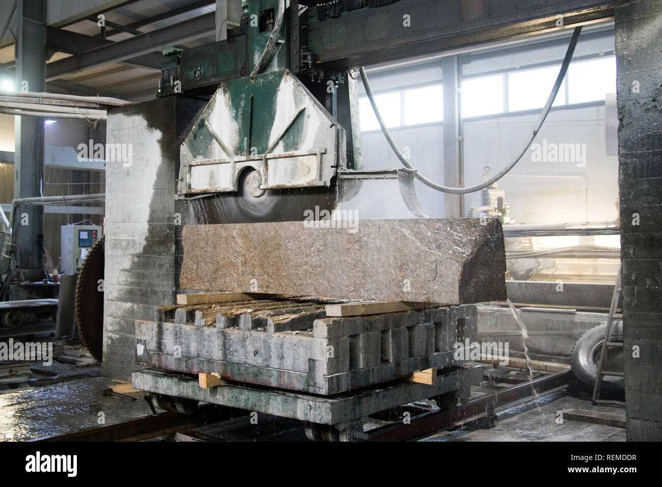 Granite processing in manufacturing. Cutting granite slab with a ...