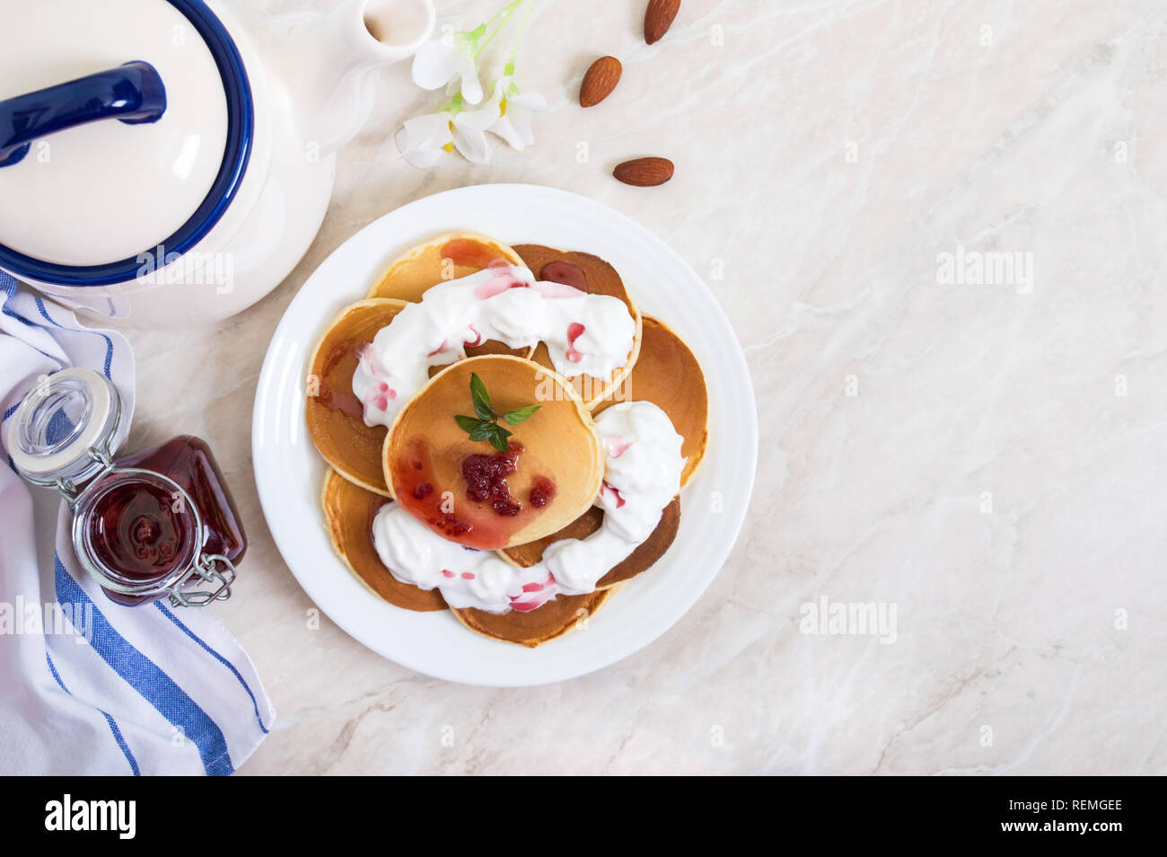 Delicious pancakes with raspberry jam and whipped cream on a white ...