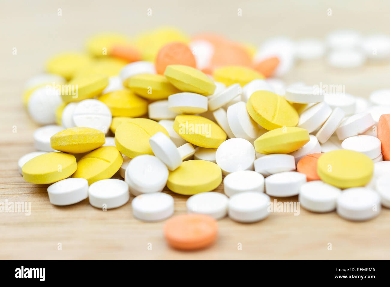 Colorful medicine pills tablets or drugs closeup on wood table ...