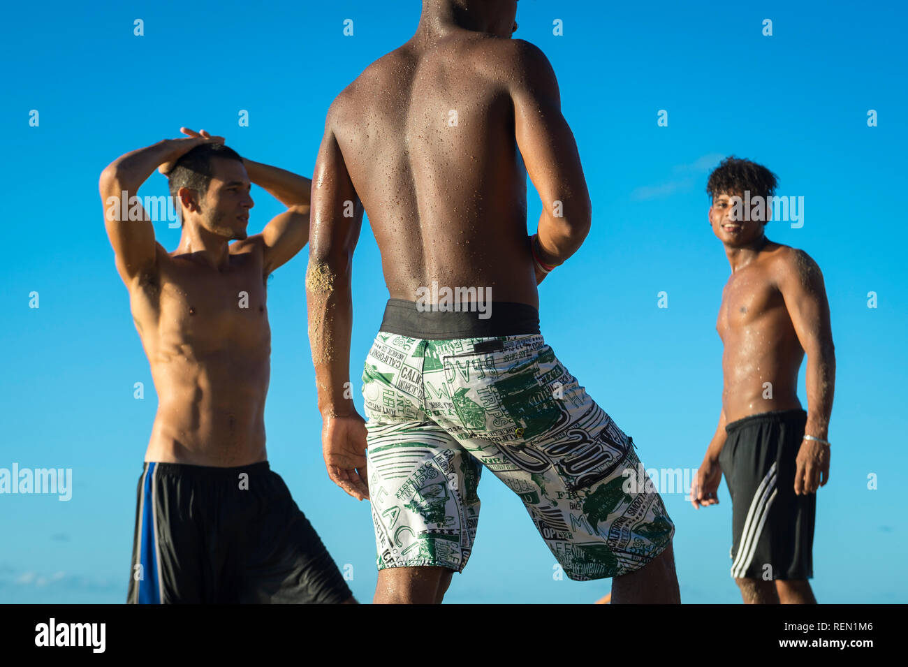 Three men on a beach hi-res stock photography and images - Alamy
