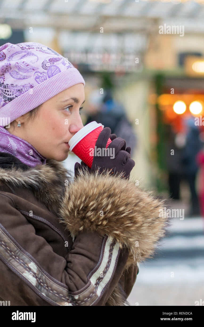 Beautiful woman drinking coffee in the street of winter clothes ...