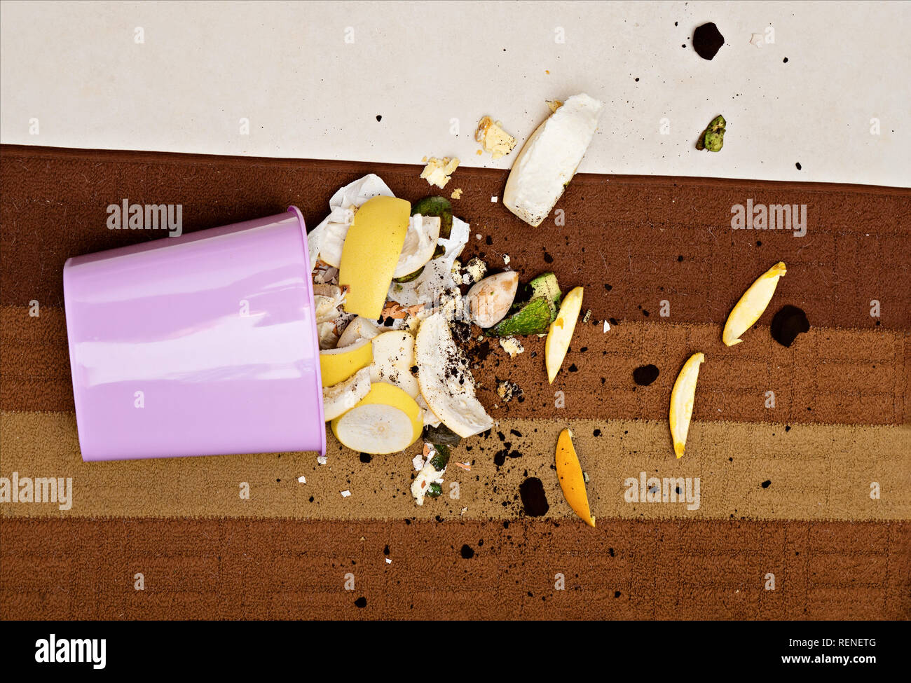 Pink plastic trashcan on floor with scattered organic waste. Waste ...