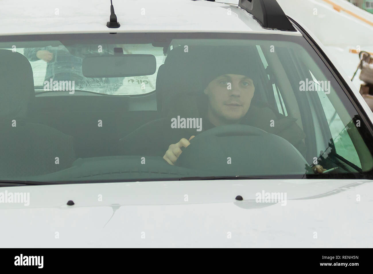 Portrait of the driver in the passenger compartment of the car behind ...