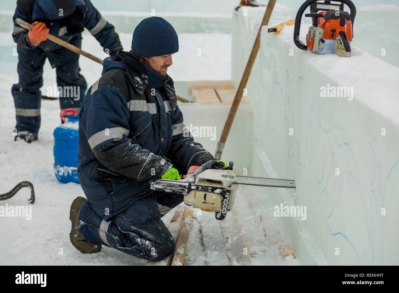 Worker saws a chainsaw ice plate in an ice town Stock Photo - Alamy