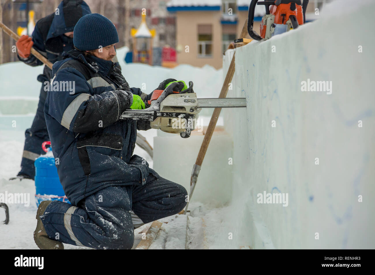 Worker saws a chainsaw ice plate in an ice town Stock Photo - Alamy