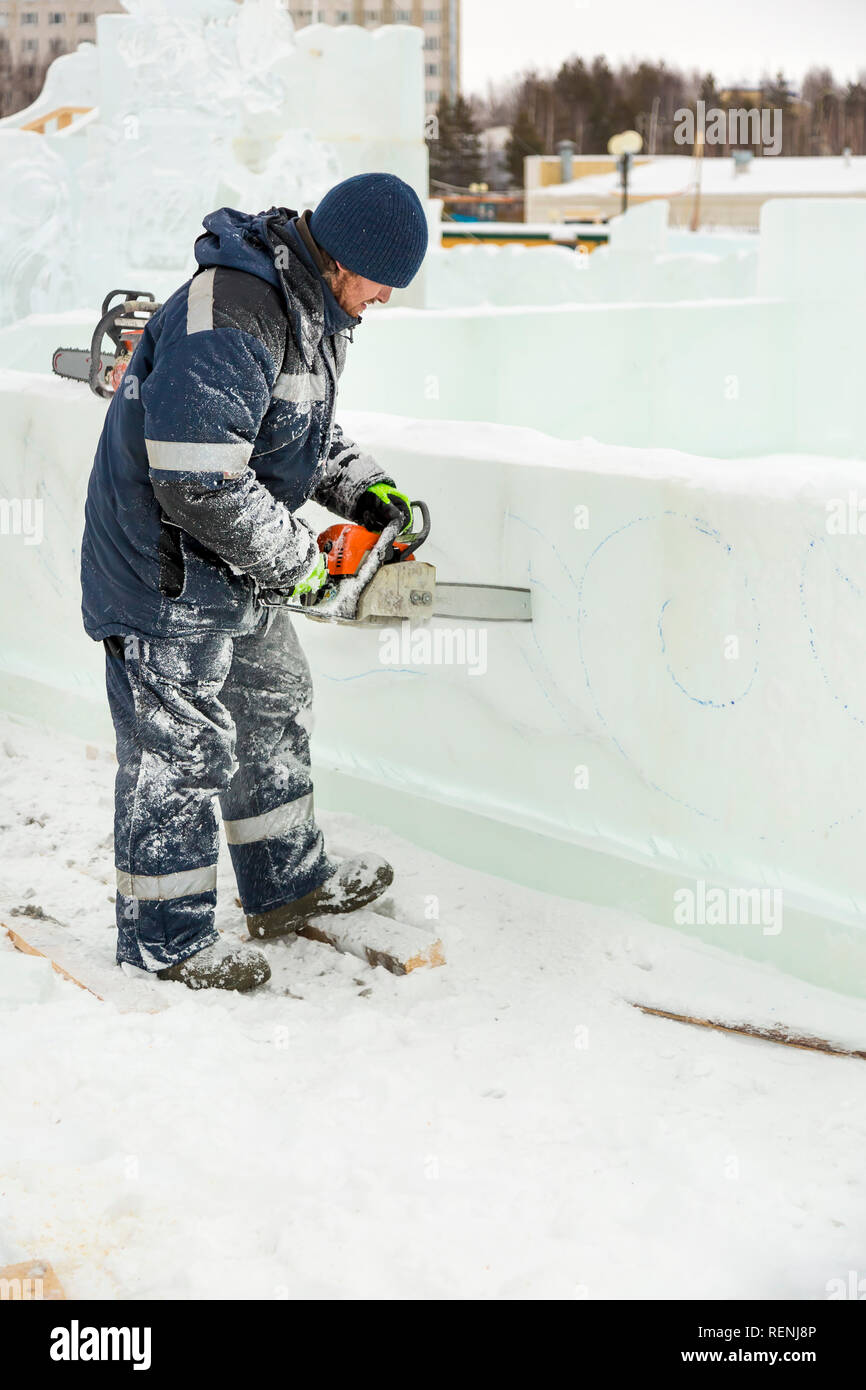 Worker saws a chainsaw ice plate in an ice town Stock Photo - Alamy