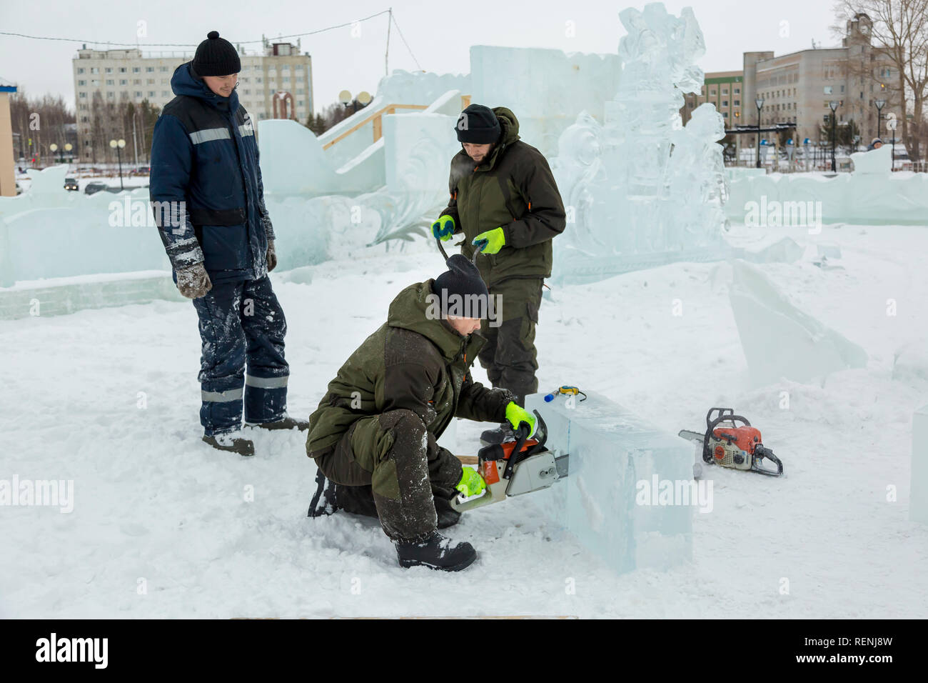 Worker saws a chainsaw ice plate in an ice town Stock Photo - Alamy