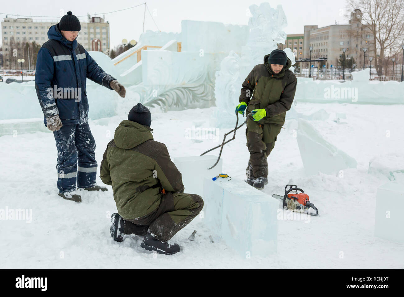 The worker pulls the ice block around the ice camp assembly site with ...