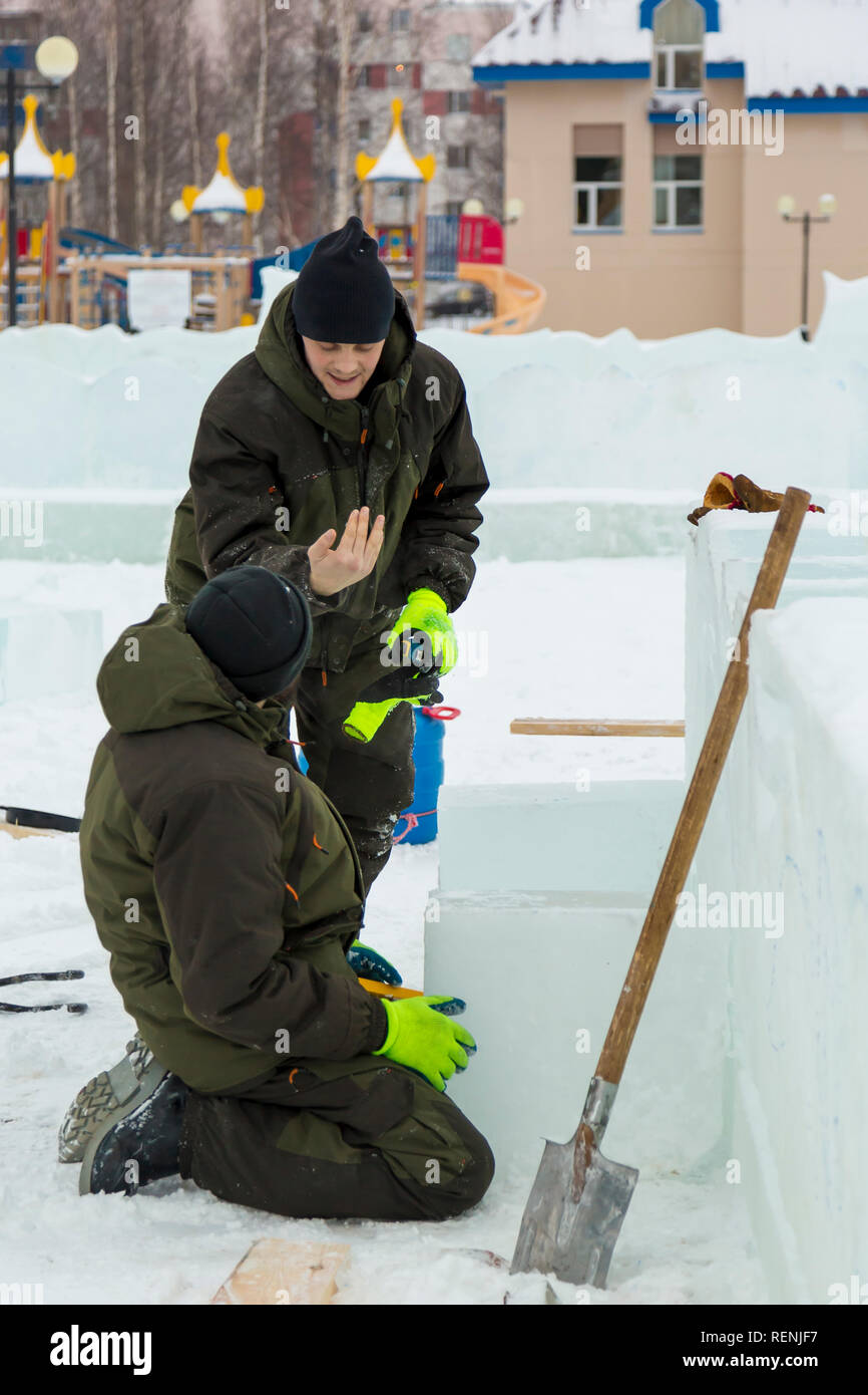 Workers assemblers mark the ice block on the construction site of the ...