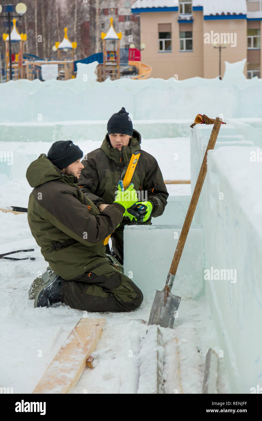 Workers assemblers mark the ice block on the construction site of the ...
