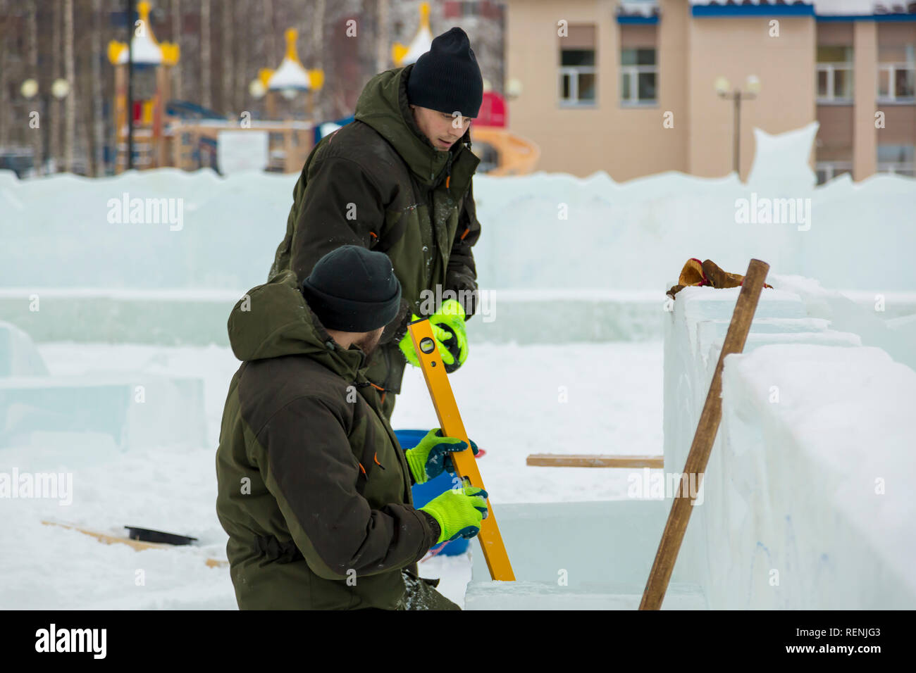 Workers assemblers mark the ice block on the construction site of the ...