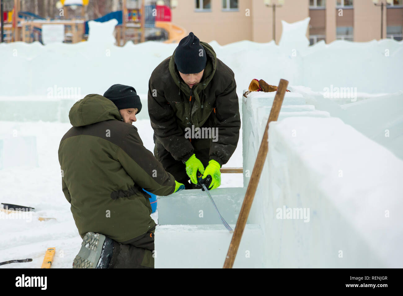 Workers assemblers mark the ice block on the construction site of the ...