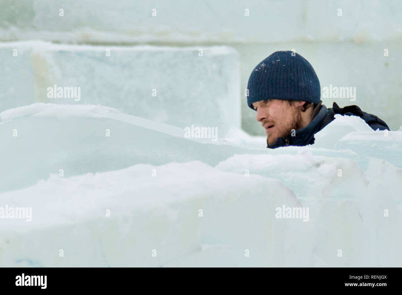 The sculptor cuts an ice figure out of ice with a chisel for Christmas ...