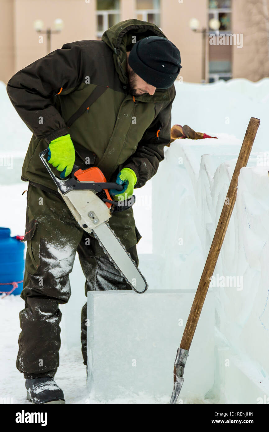Worker saws a chainsaw ice plate in an ice town Stock Photo - Alamy