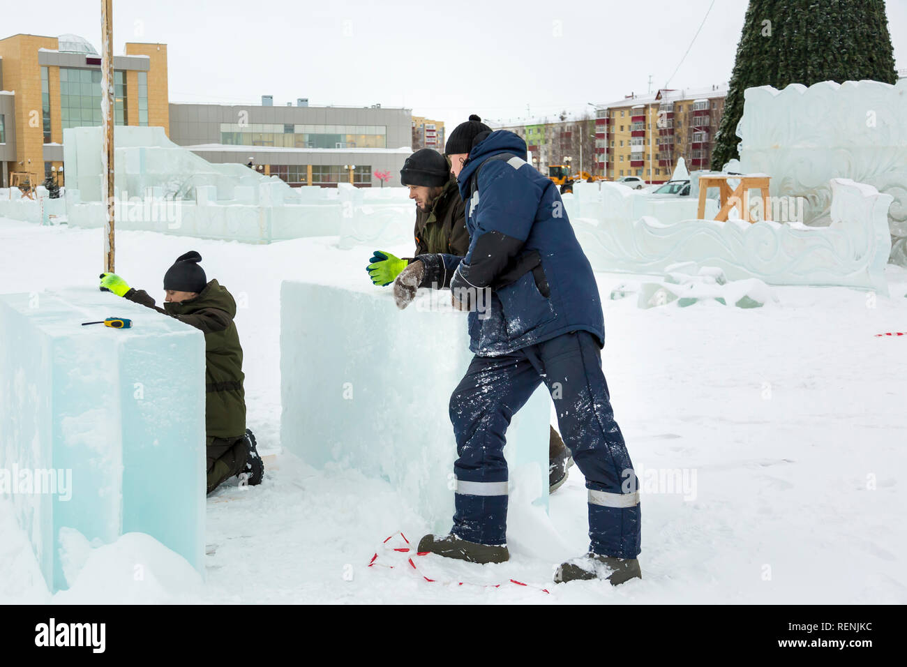 Workers assemblers mark the ice block on the construction site of the ...
