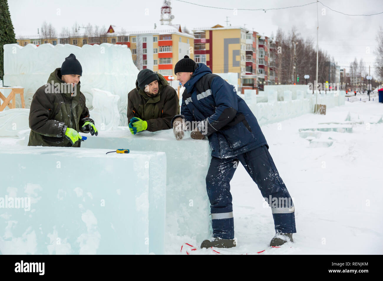 Workers assemblers mark the ice block on the construction site of the ...