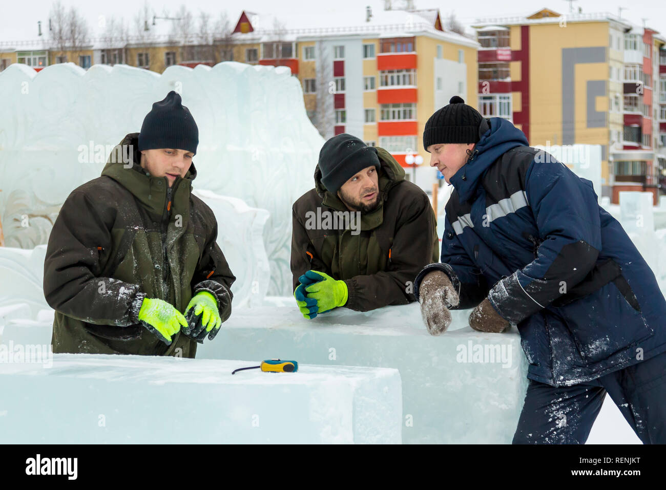 Workers assemblers mark the ice block on the construction site of the ...